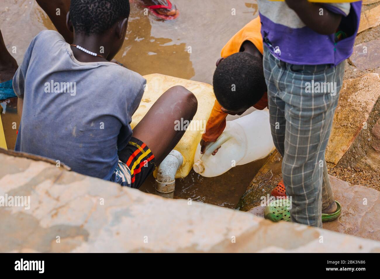 People getting water at a well with water cans Stock Photo - Alamy