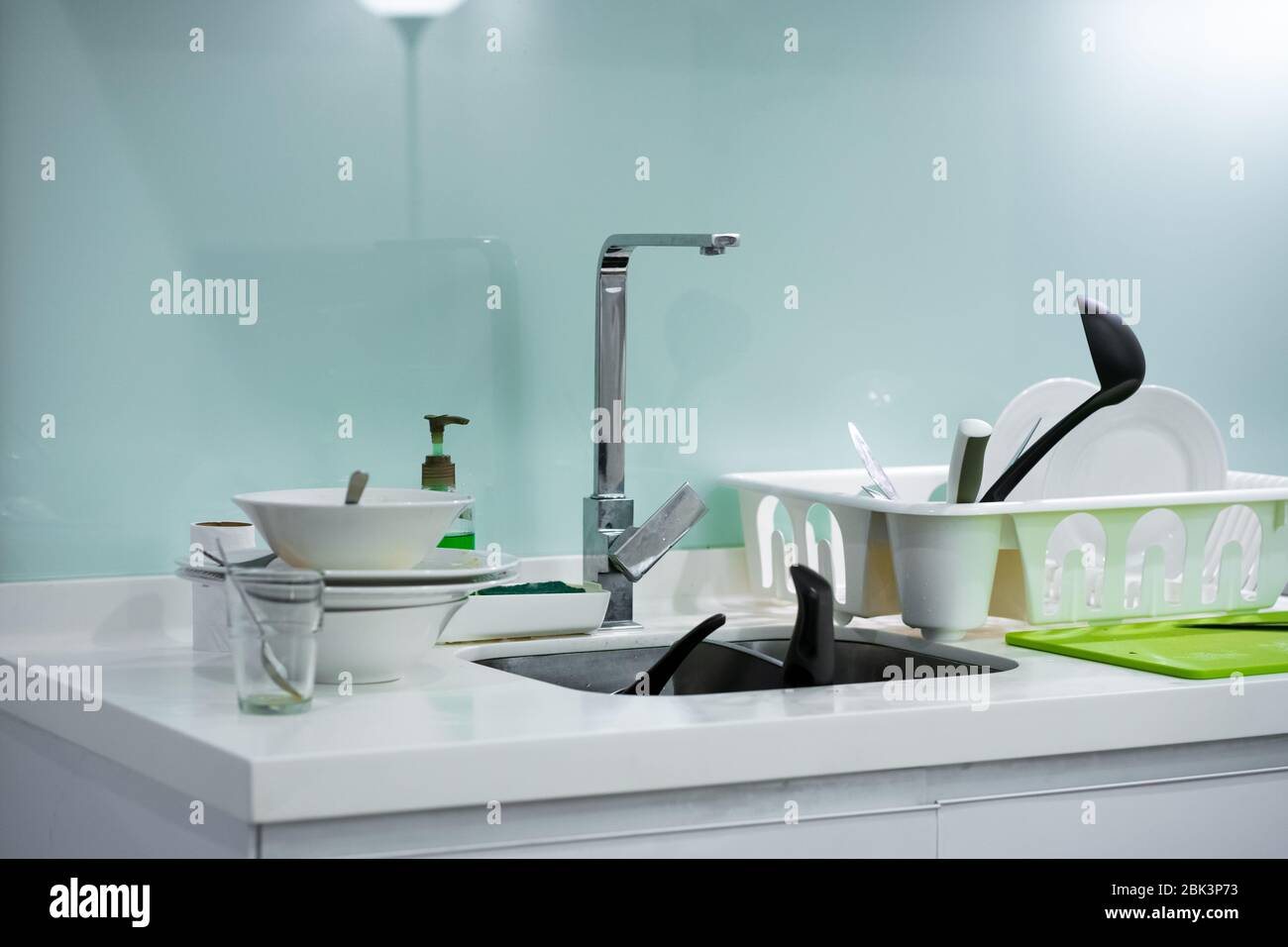 A mountain of dirty dishes in the kitchen sink. Mess in the house Stock ...