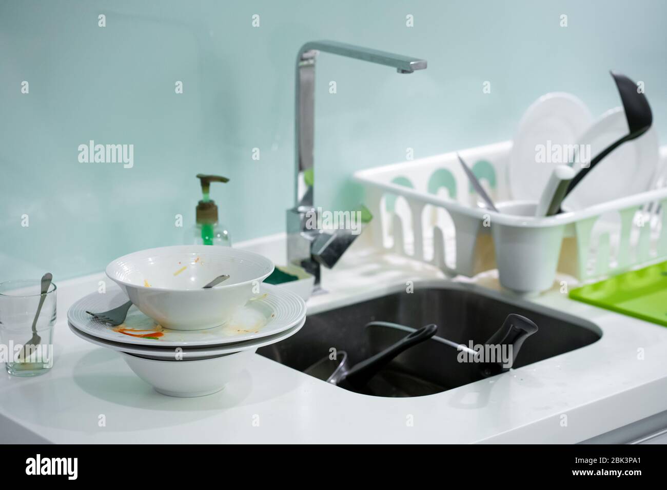 A mountain of dirty dishes in the kitchen sink. Mess in the house Stock ...