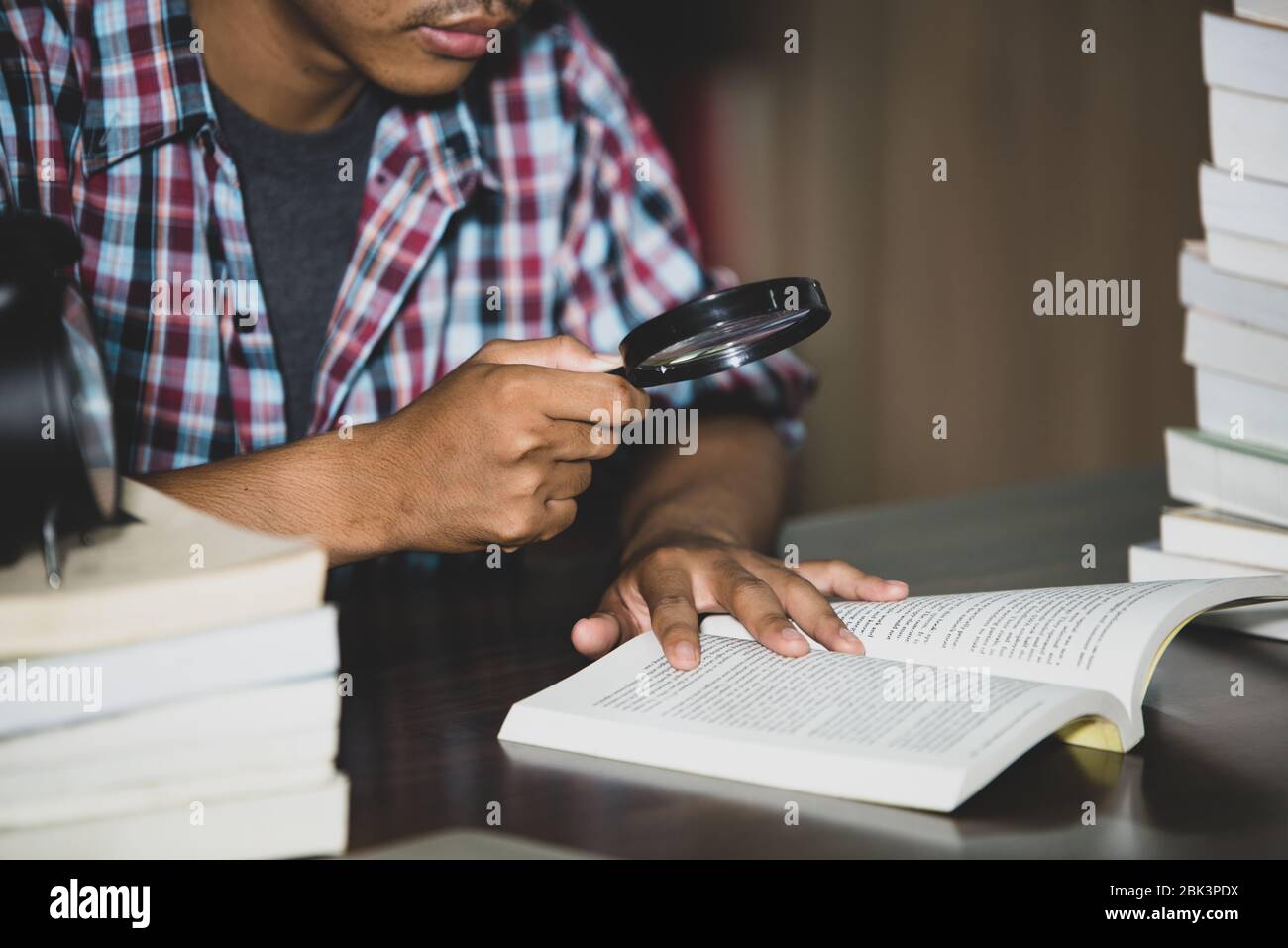 Educational theme: Close -up Student looking through a magnifying glass ...