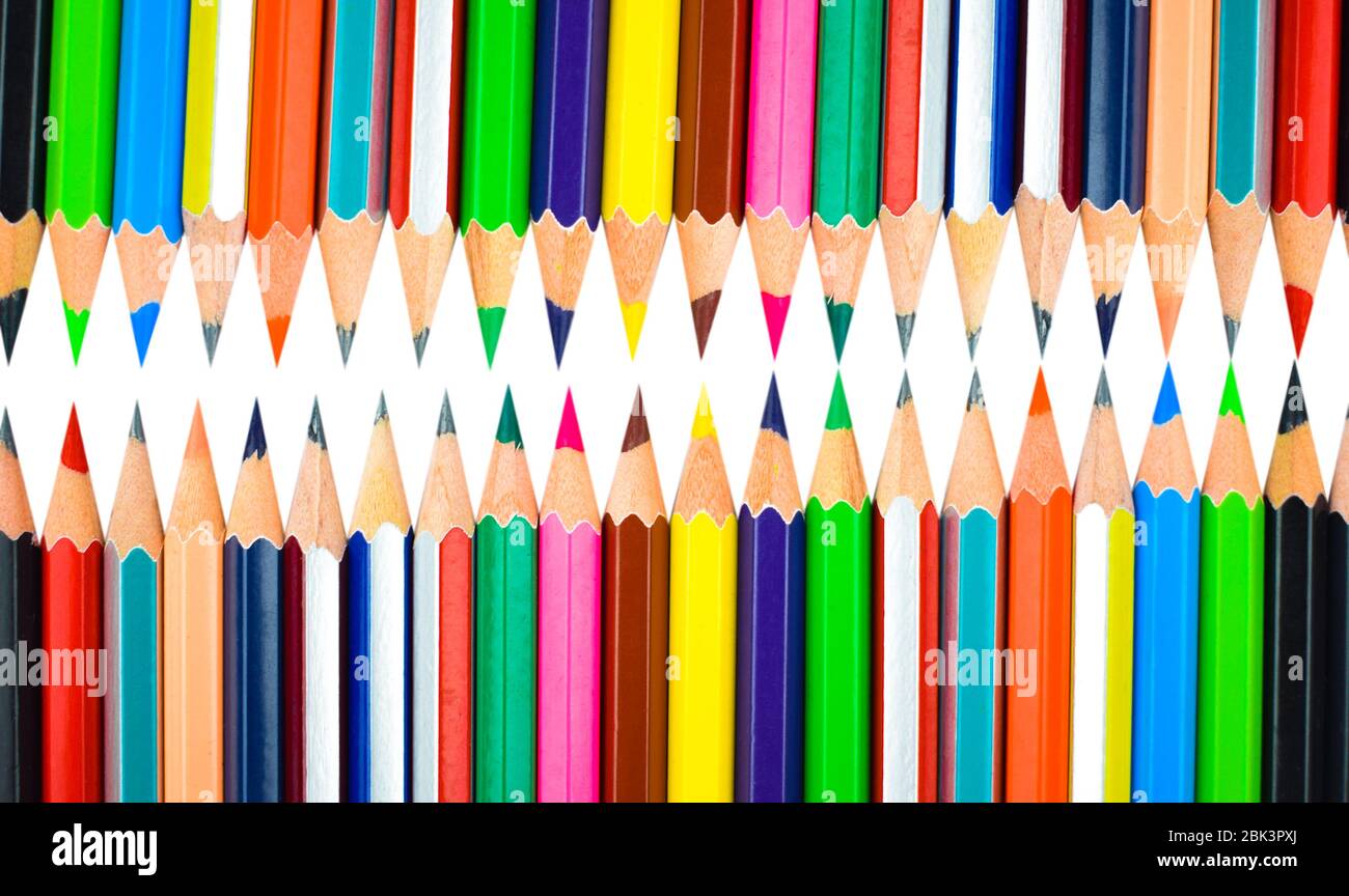 Two row of different color pencil crayons placed on a white isolated ...