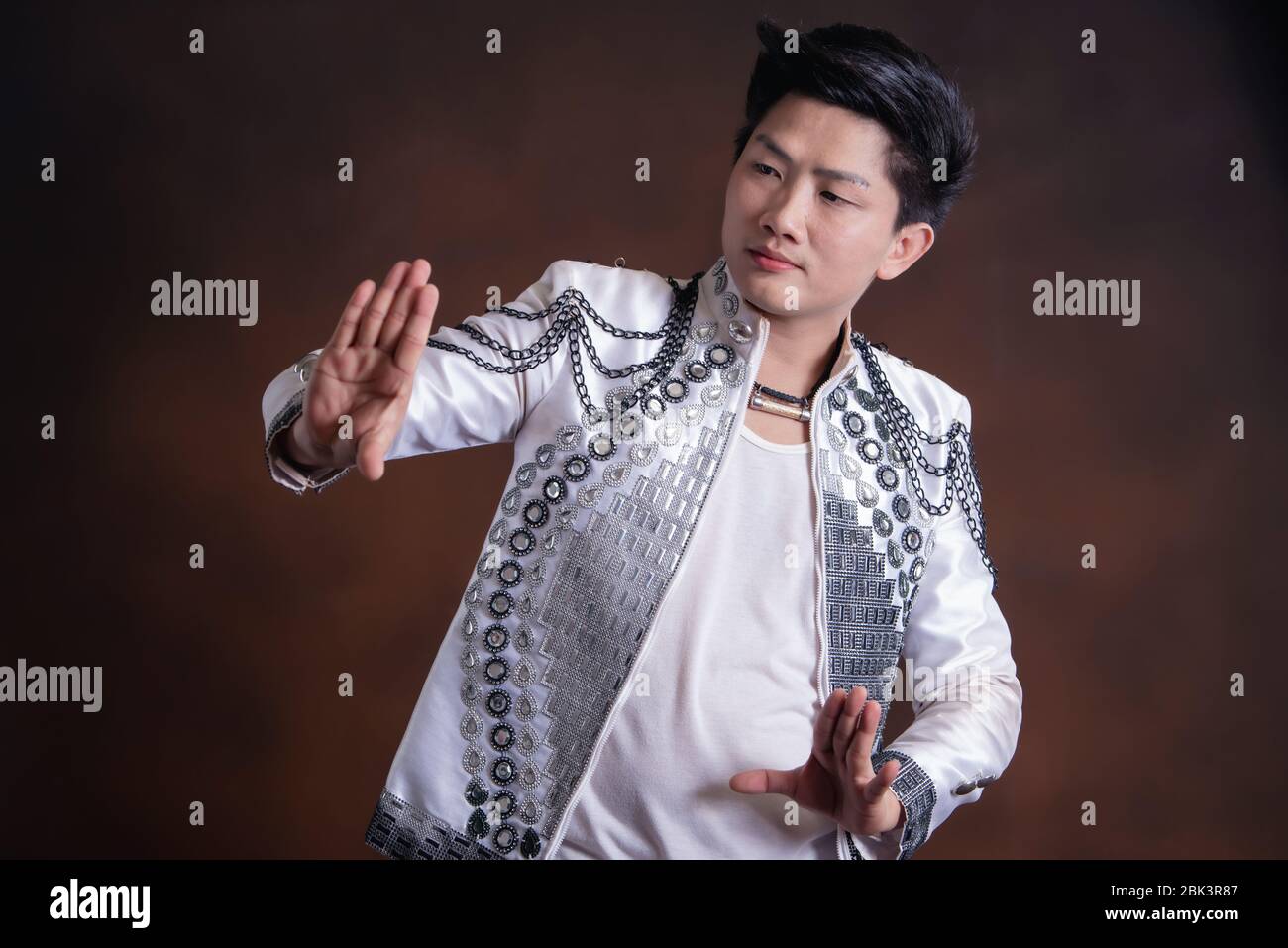 Young handsome singer man in casual clothes with on color background ...