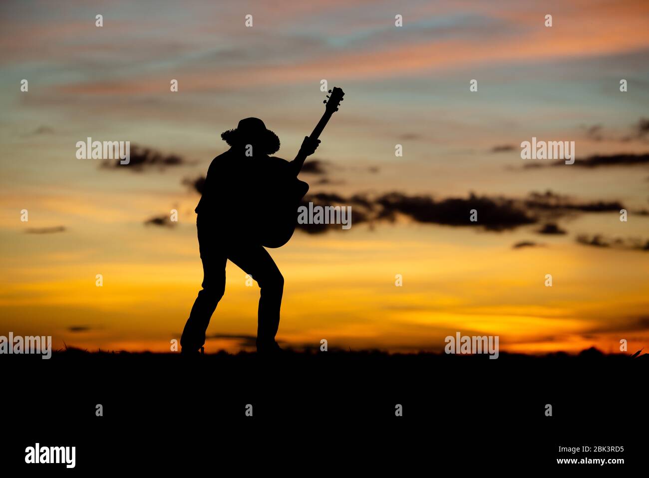Silhouette girl guitarist on a sunset background Stock Photo - Alamy