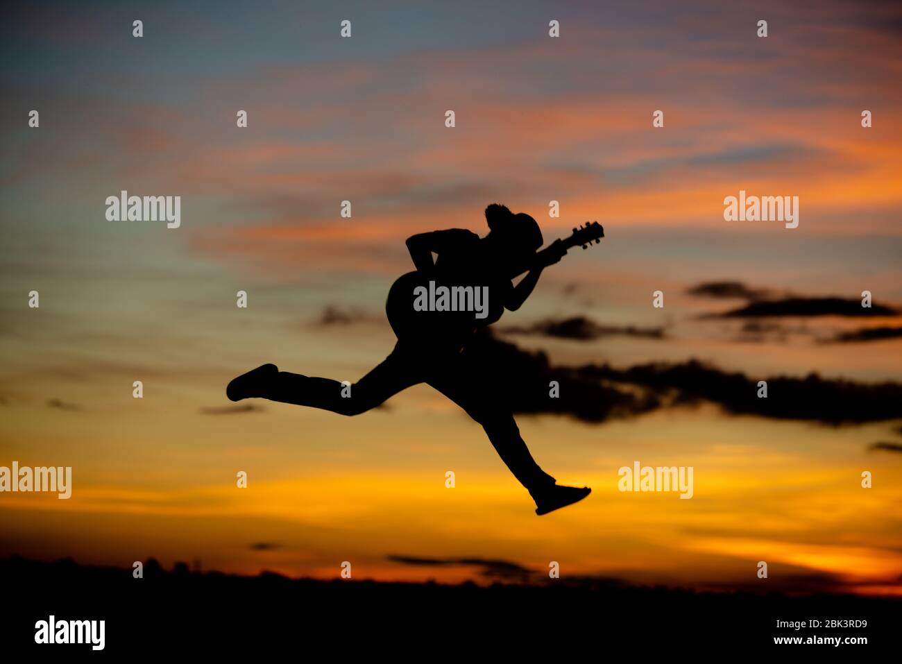 Silhouette girl guitarist on a sunset background Stock Photo - Alamy