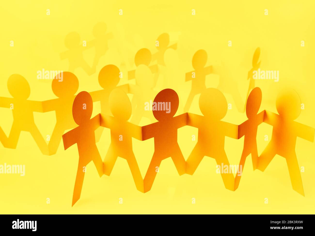 Paper chain team holding hands. Teamwork. Partnership Stock Photo - Alamy