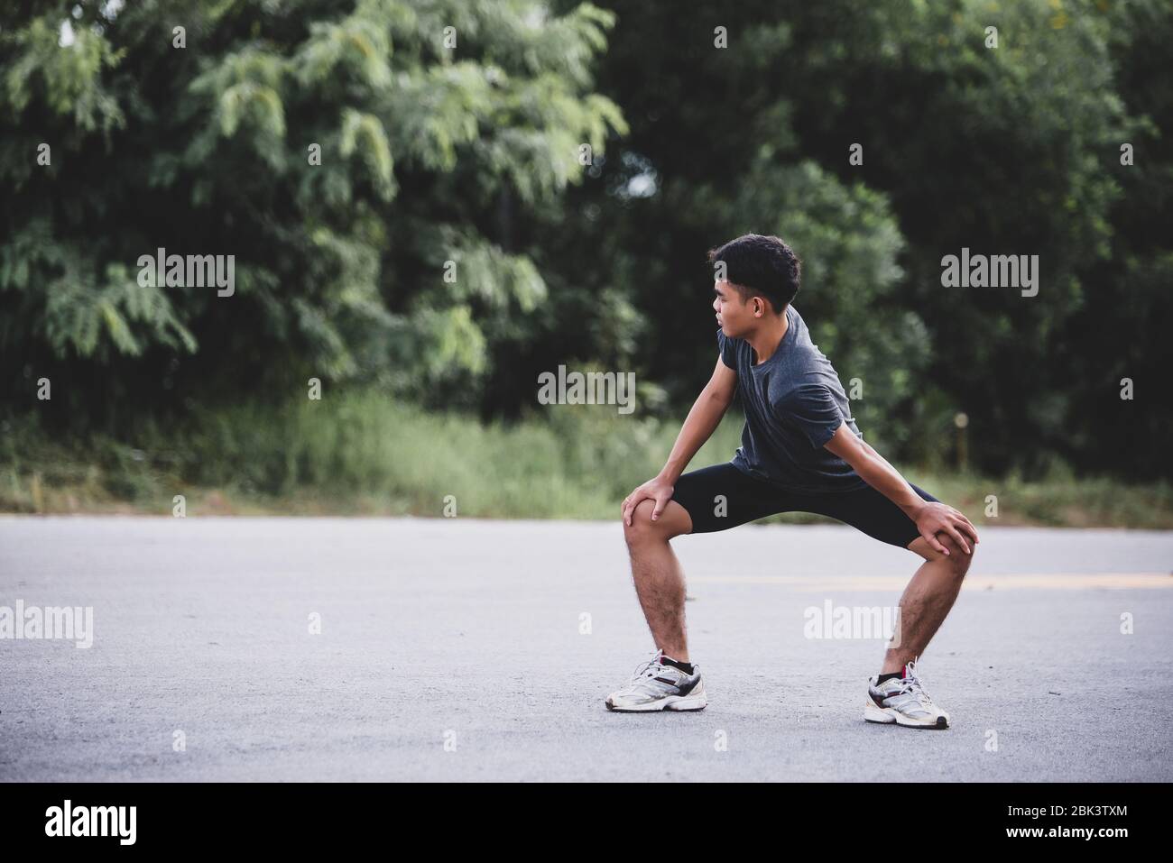 Attractive man runner doing stretching hi-res stock photography and ...