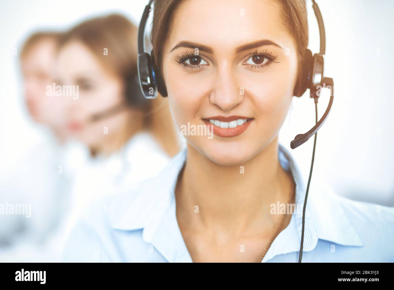 Call center. Focus on beautiful woman in headset Stock Photo - Alamy