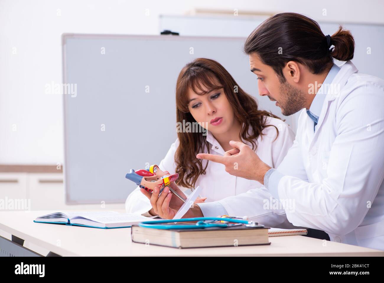 Young male doctor cardiologist and female student in the classroom ...