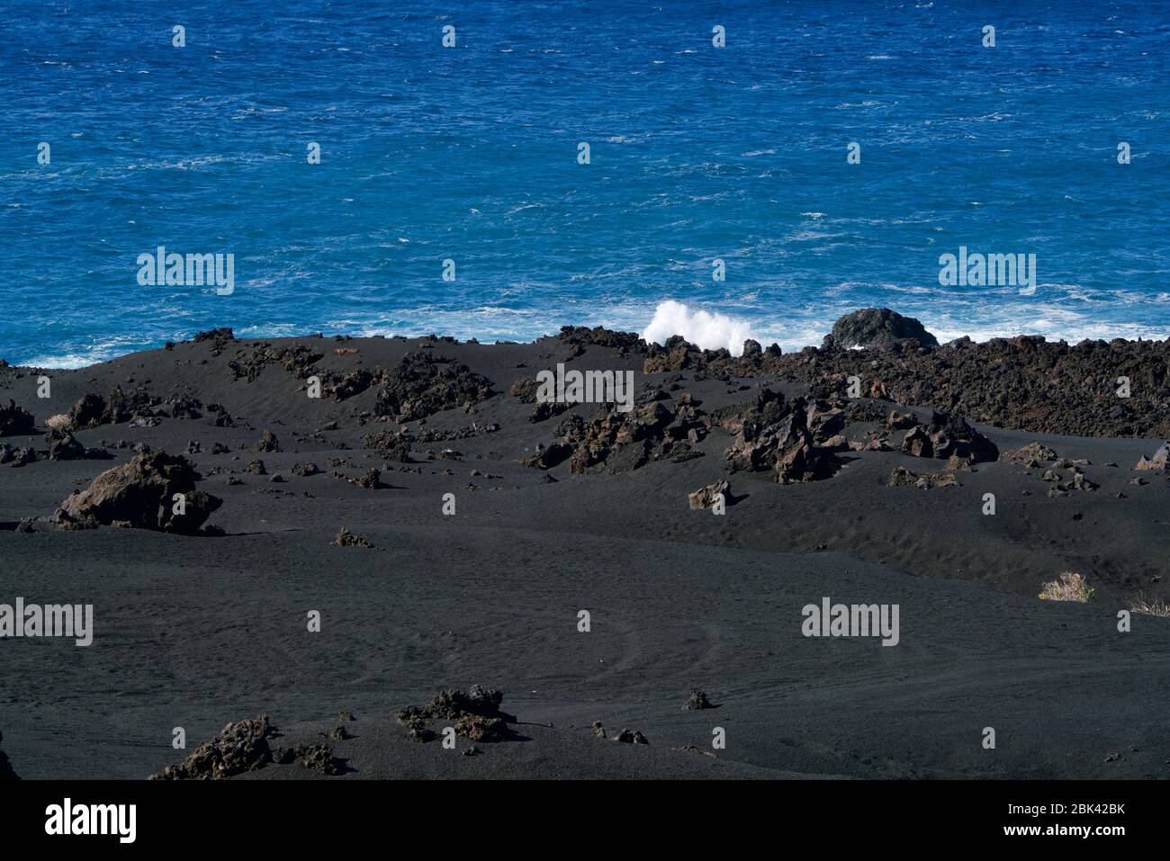 Black volcanic beach, the blue ocean in the background Stock Photo - Alamy