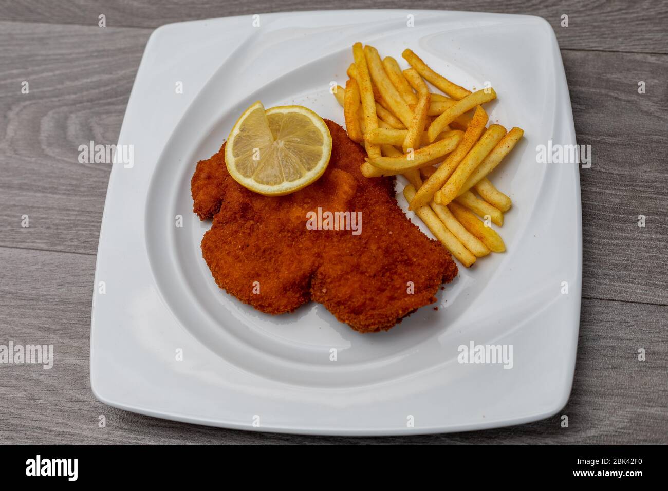 Breaded viennese schnitzel with french fries Stock Photo - Alamy