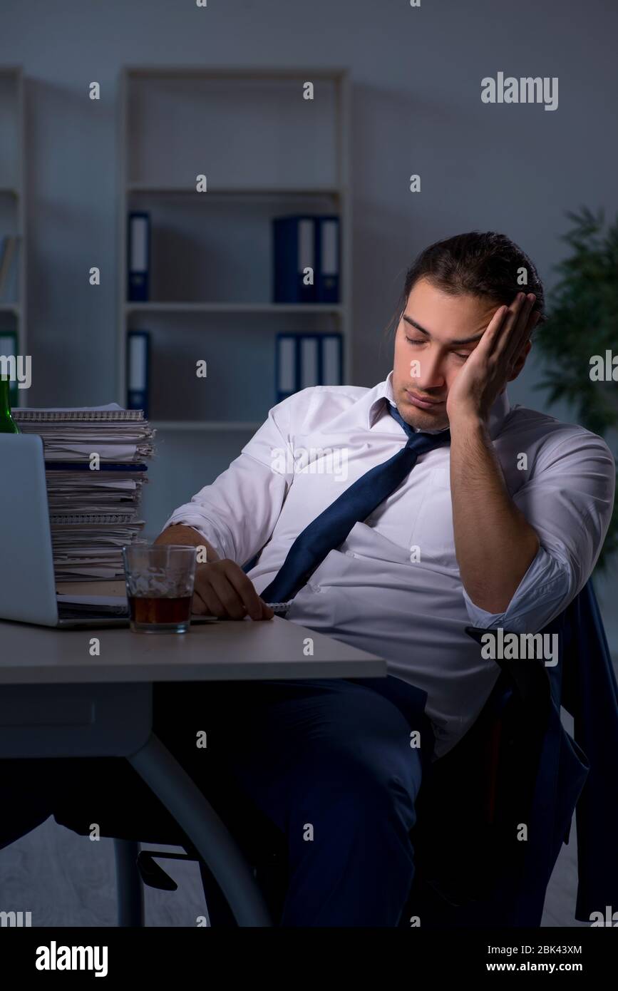 Alcohol addicted businessman working late Stock Photo - Alamy