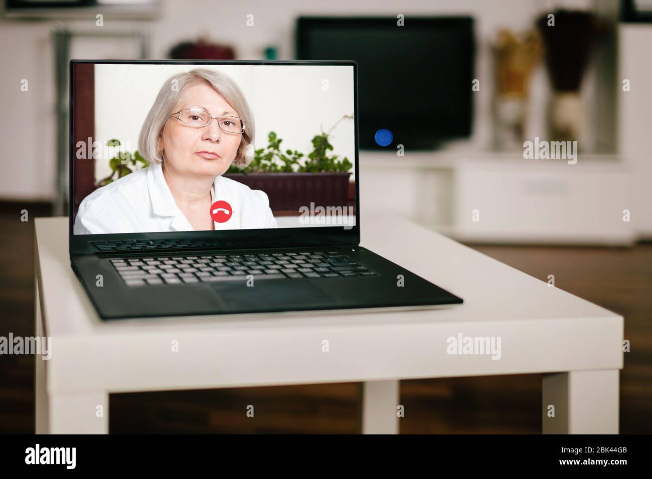 Telemedicine concept. Doctor GP on a computer screen, living room home ...