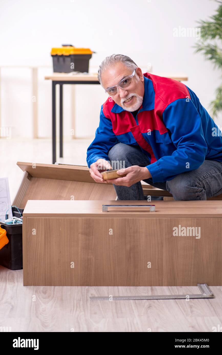 Old carpenter working indoors on furniture Stock Photo - Alamy
