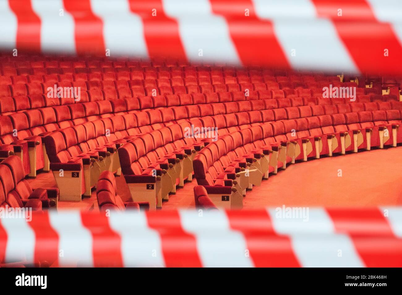 Empty cinema seats. Closed theater hall interior with red warning tape ...