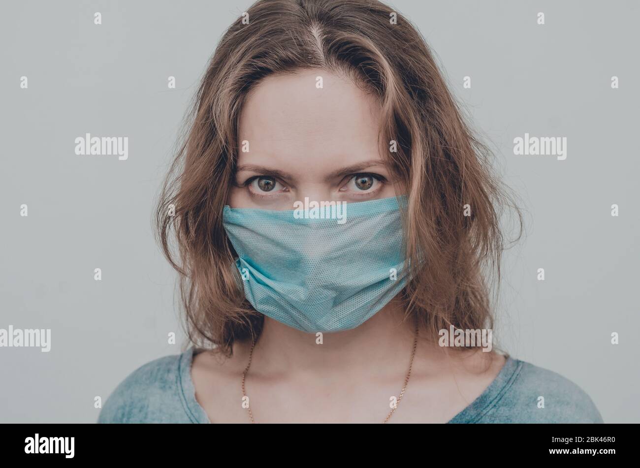 Portrait of a woman wearing a medical mask looking at camera, isolated ...