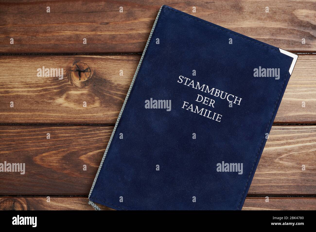 The three German words on the blue book on wooden background means ...