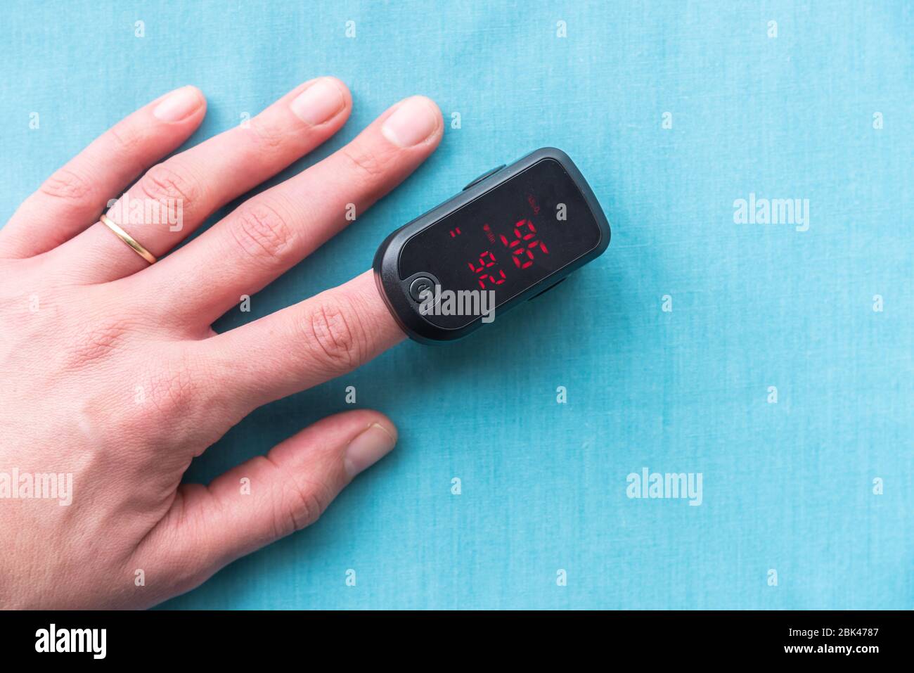 Close-up of adult woman's hand wearing pulse oximeter to measure blood ...