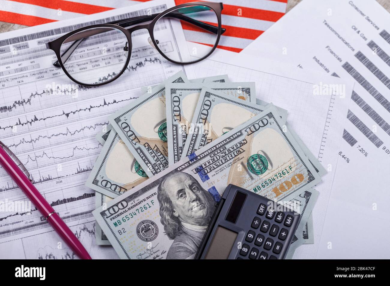 The concept of stock trading. One hundred dollar bills and pen in the ...
