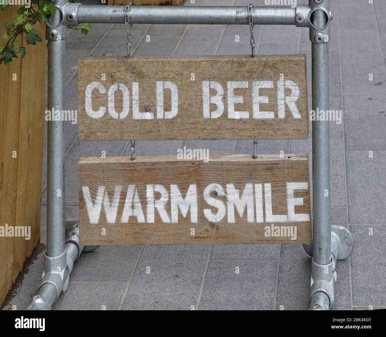 Cold beer and warm smile signs on wooden frame in front of English pub ...
