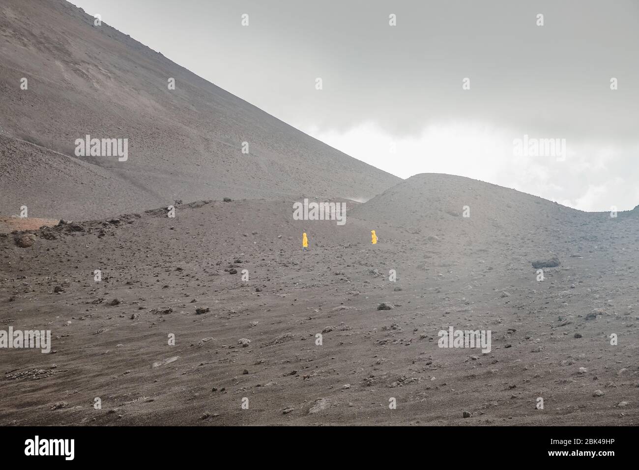 Top of crater Mount Etna volcano, frozen cold lava smokes, thick clouds ...