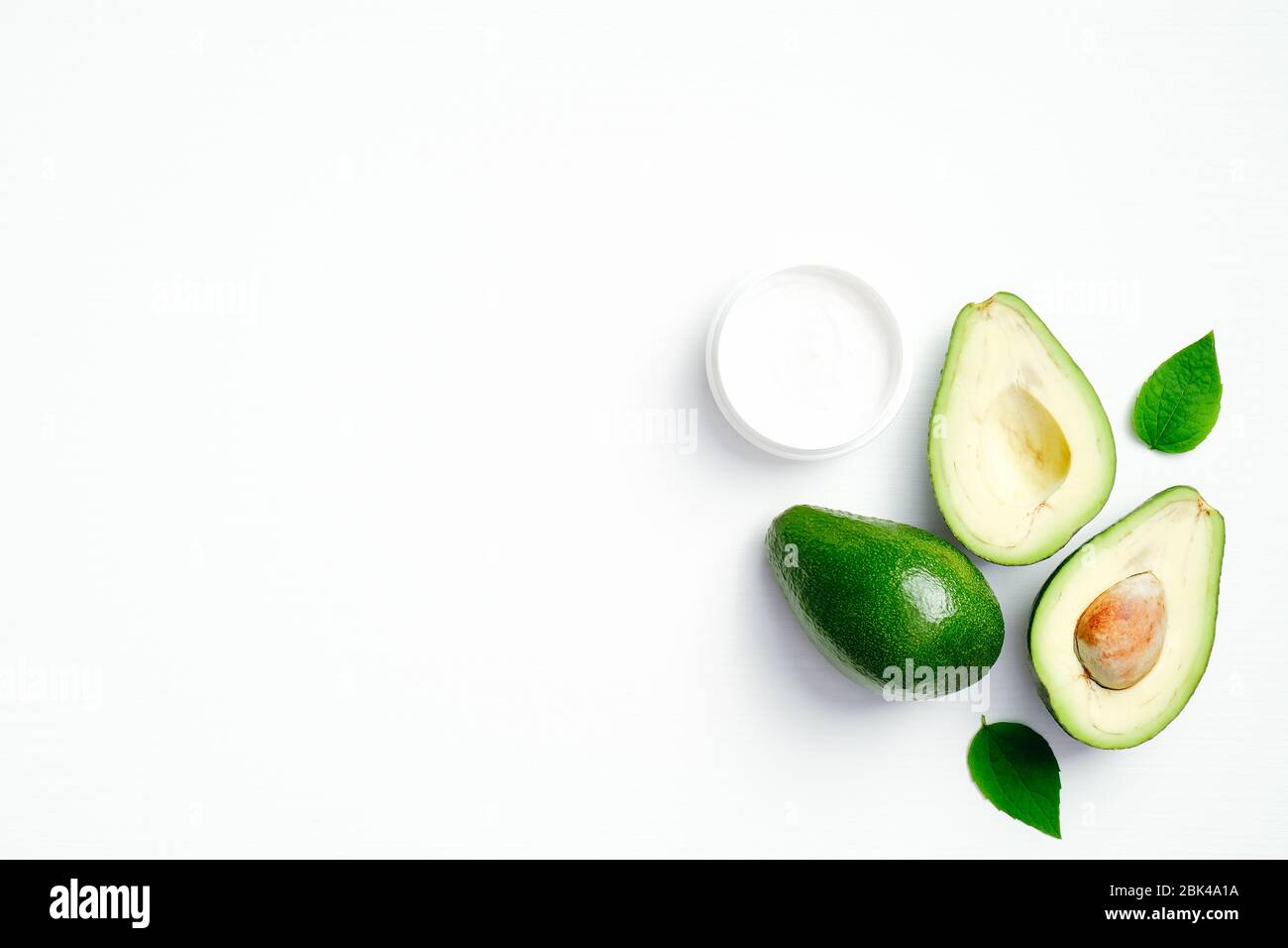 Fresh ripe avocado and natural cosmetic cream on white background. Flat ...