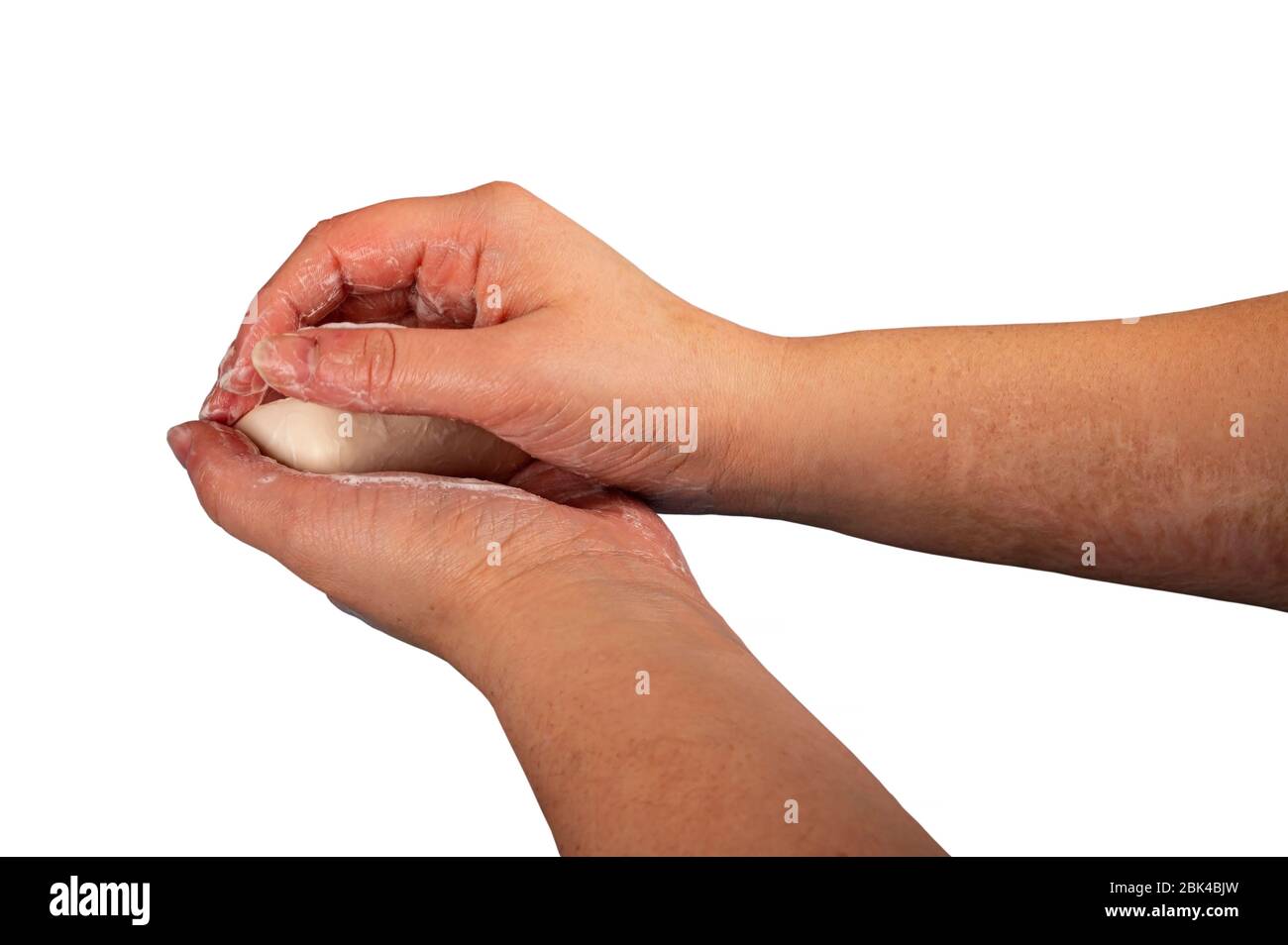 Someone is soaping their hands with a piece of toilet soap. Close up ...