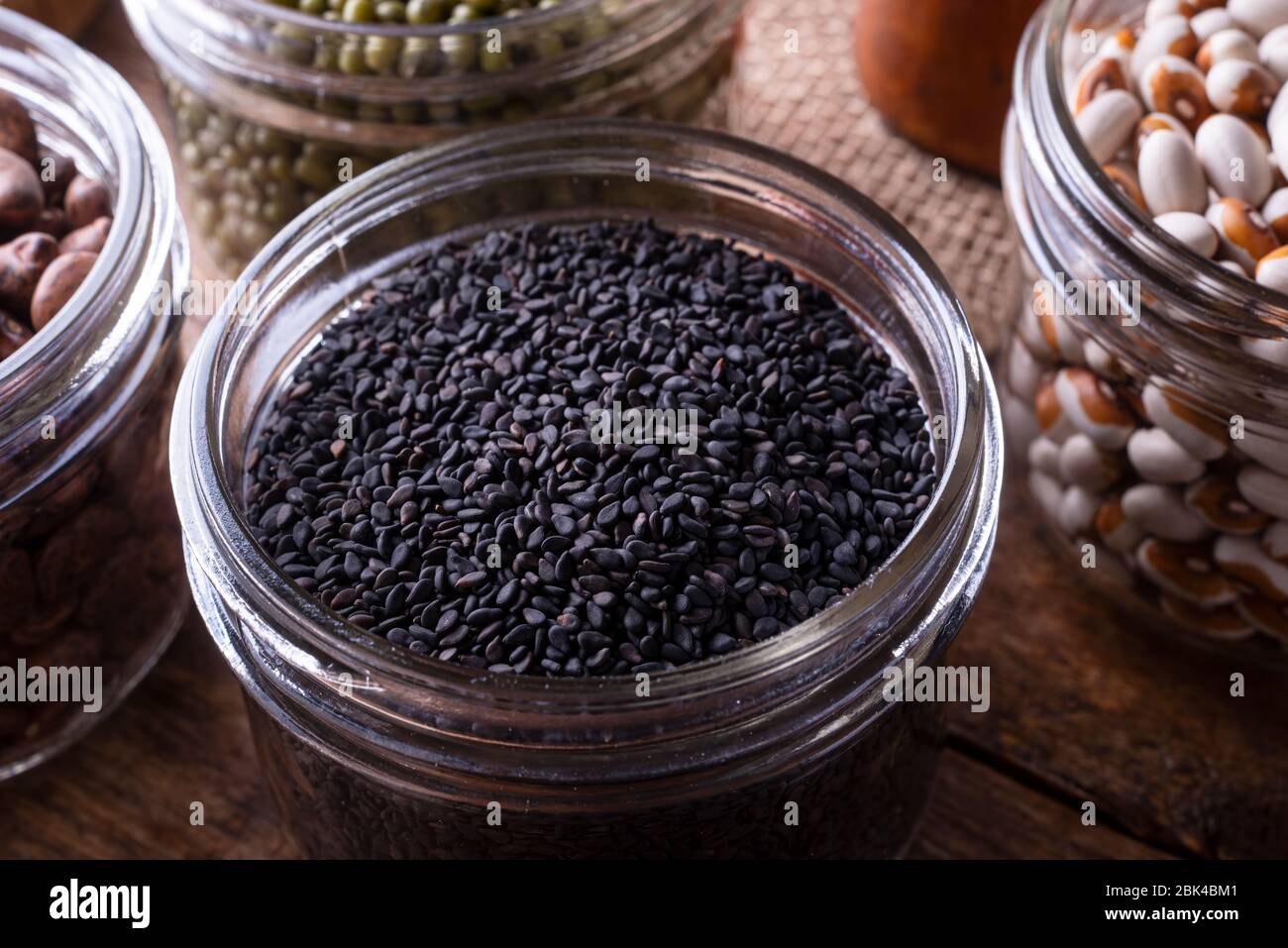 Black sesame seeds in a glass storage container Stock Photo - Alamy
