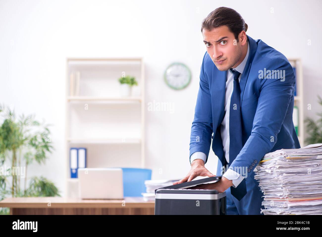 Young employee making copies at copying machine Stock Photo - Alamy