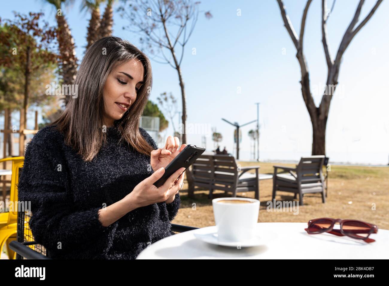 Beautiful young woman having Zoom video conference call via smart phone ...