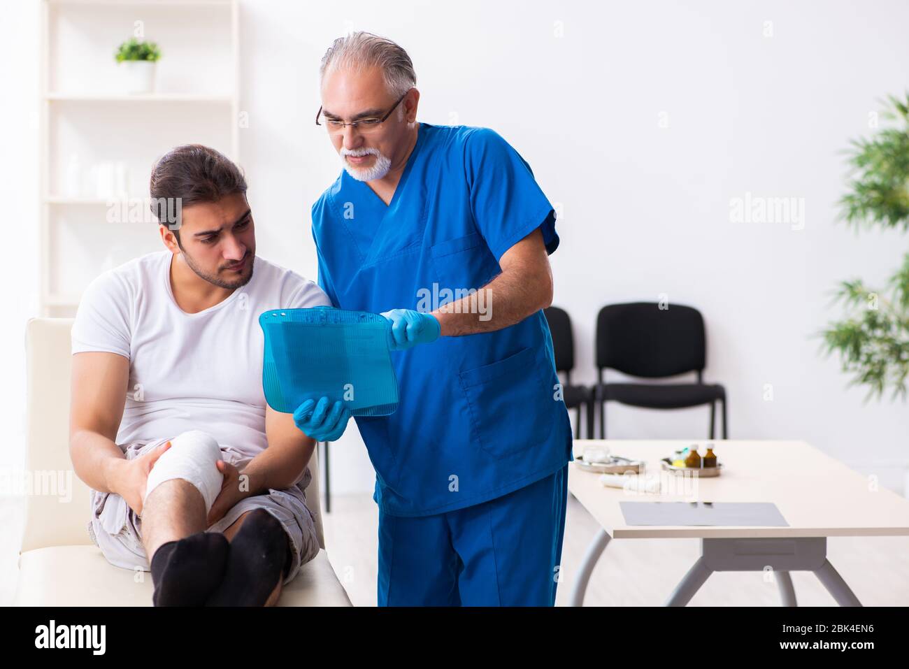 Leg injured man visiting doctor in first aid concept Stock Photo - Alamy