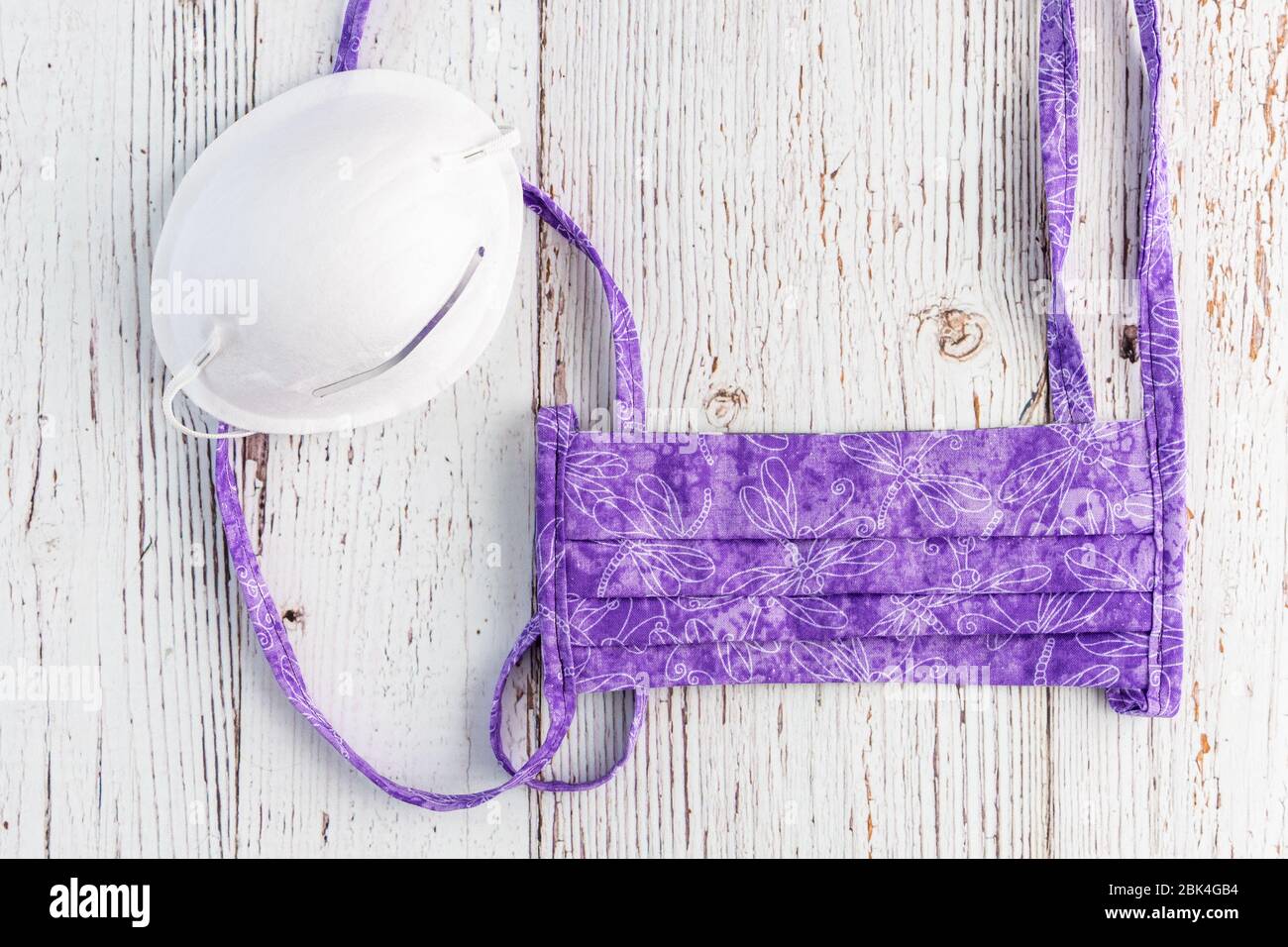 Handmade purple fabric protective face mask, and white commercial mask ...