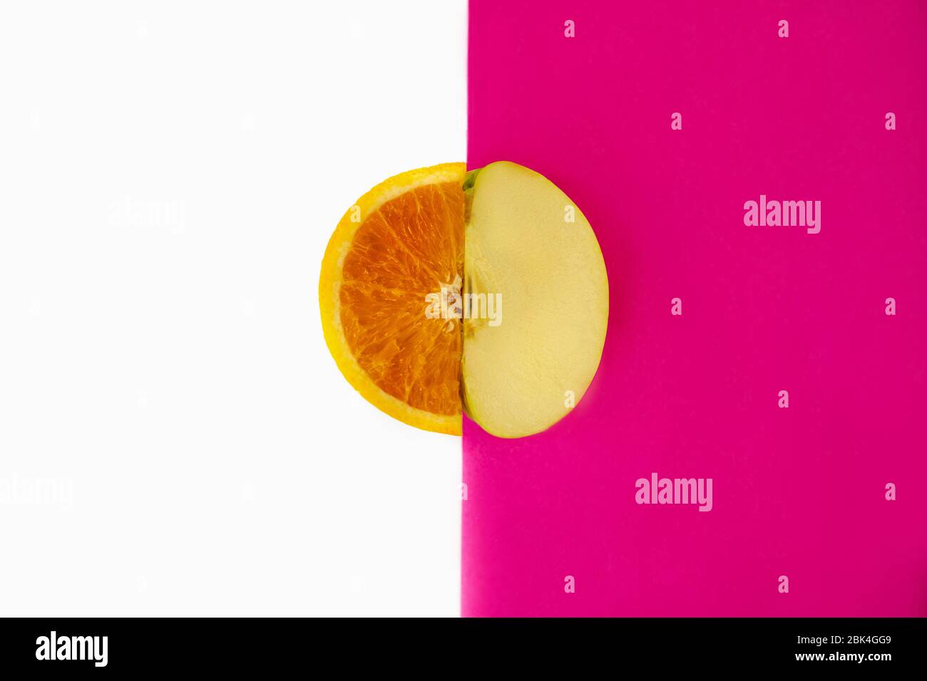 Half an apple and an orange divide the white and purple sheet in two ...