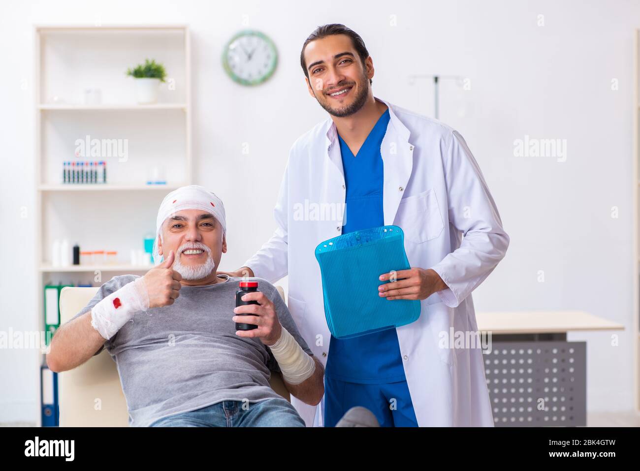 Young male doctor and old patient in first aid Stock Photo - Alamy
