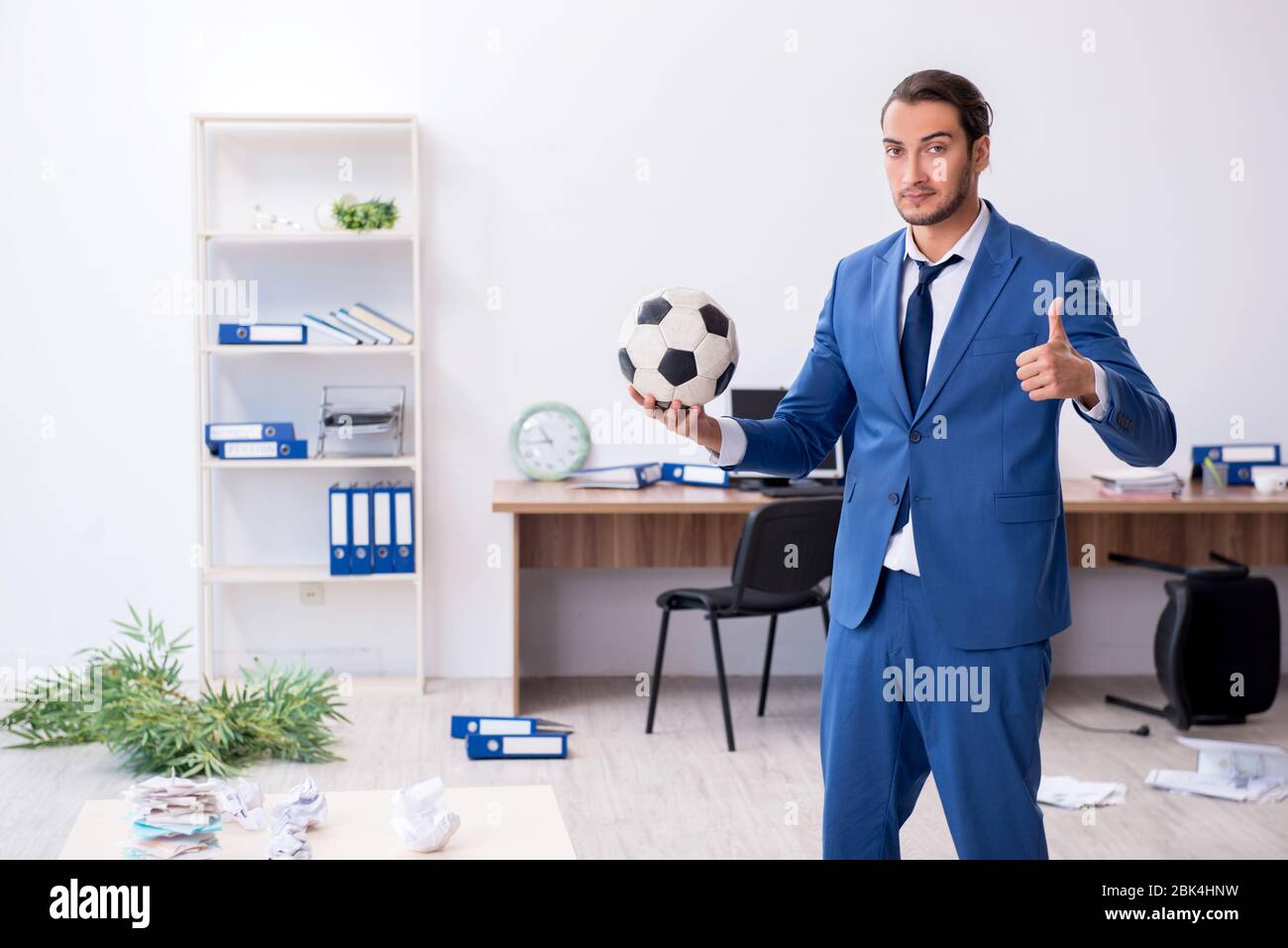 Young employee playing football in the office Stock Photo - Alamy