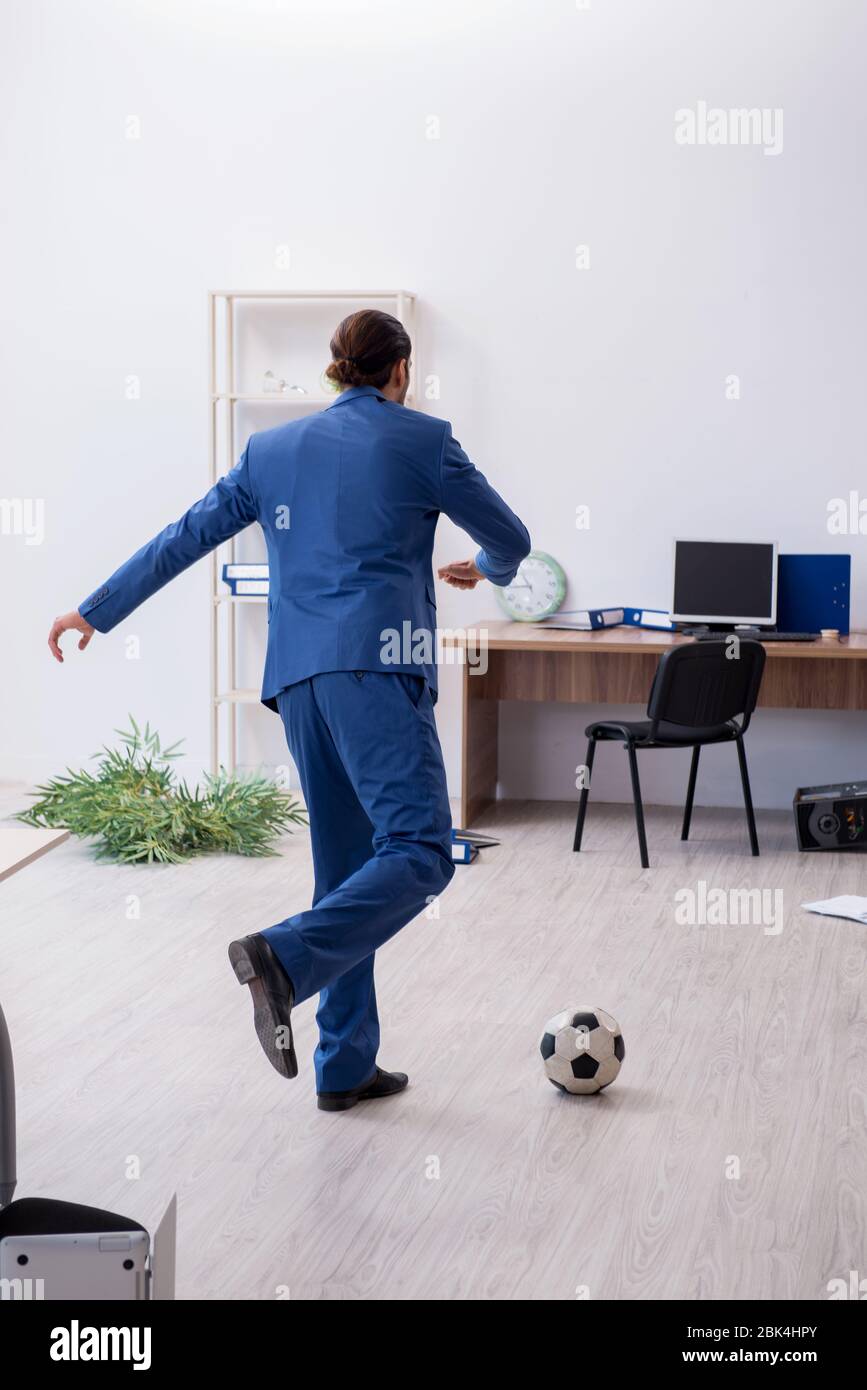 Young employee playing football in the office Stock Photo - Alamy