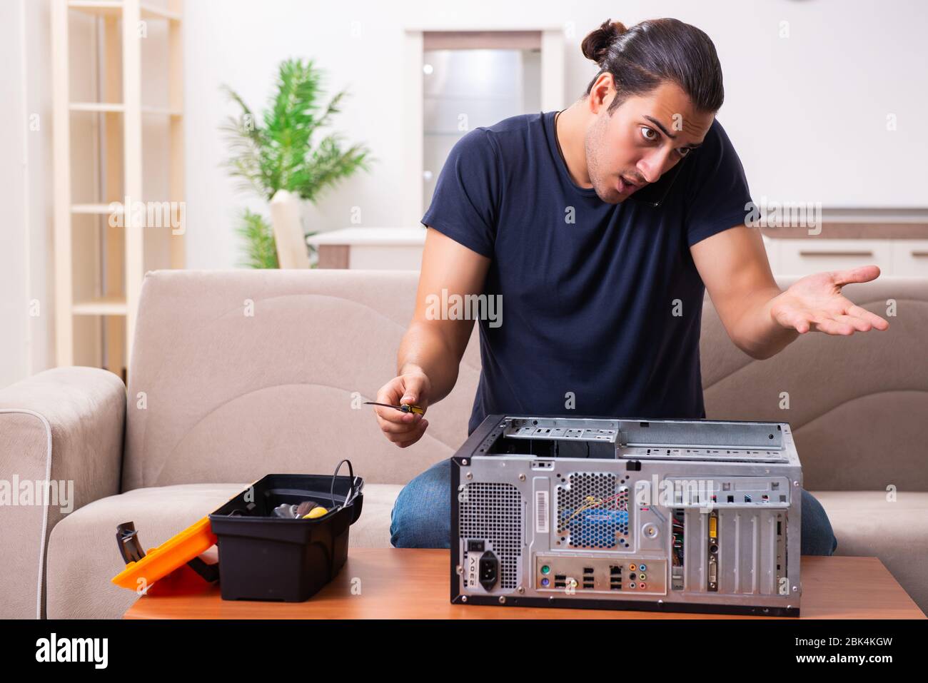 Young man repairing computer at the home Stock Photo - Alamy