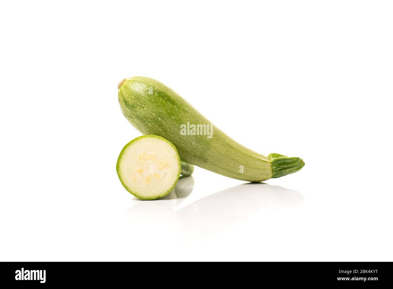 Sliced fresh zucchini, two parts of ripe vegetable on a white ...