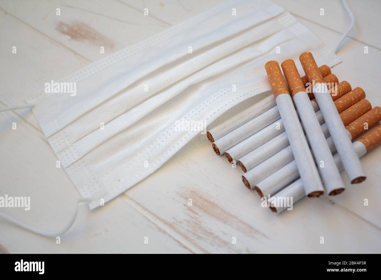 Medical face mask and cigarettes. Pneumonia, COVID-19, lung diseases ...