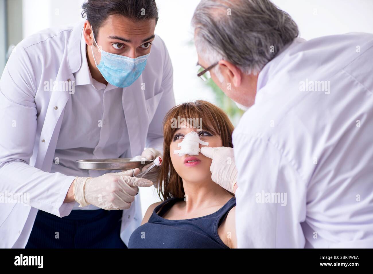 Two male doctors and young woman in surgery concept Stock Photo - Alamy