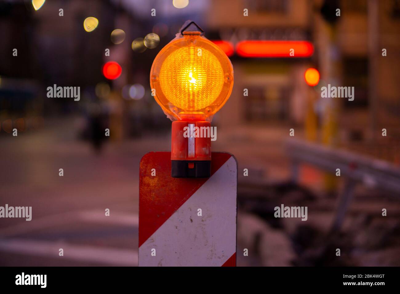 Road construction sign light in orange on a red and white stand Stock ...