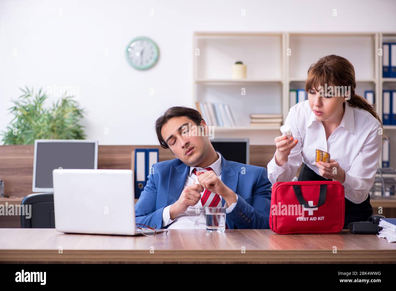 Employee receiving first aid in office Stock Photo - Alamy
