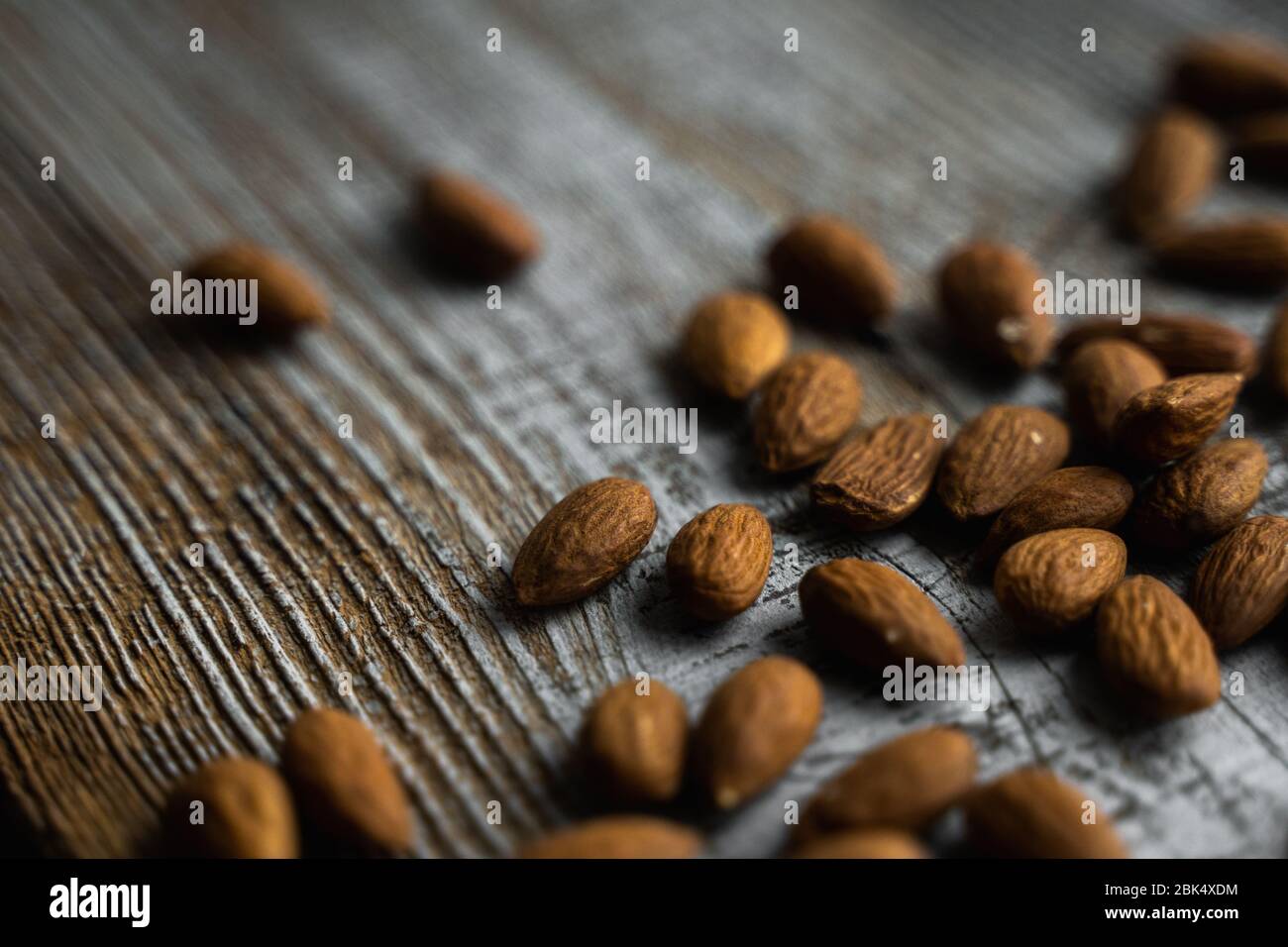 Almonds scattered on the wooden vintage table. Almond is a healthy ...