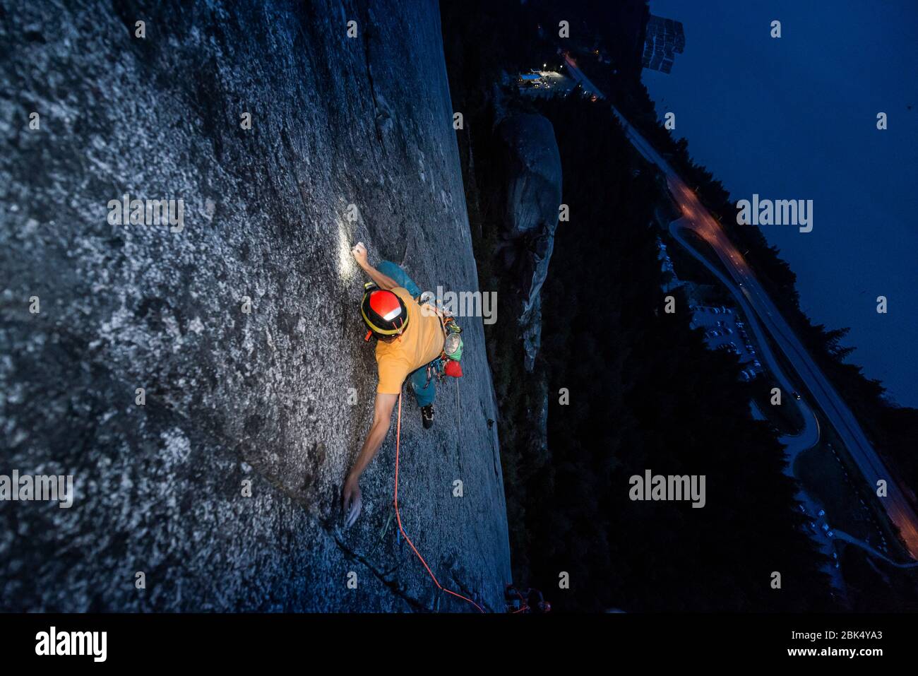 Top view man rock climbing at night above the sea and highway Stock ...