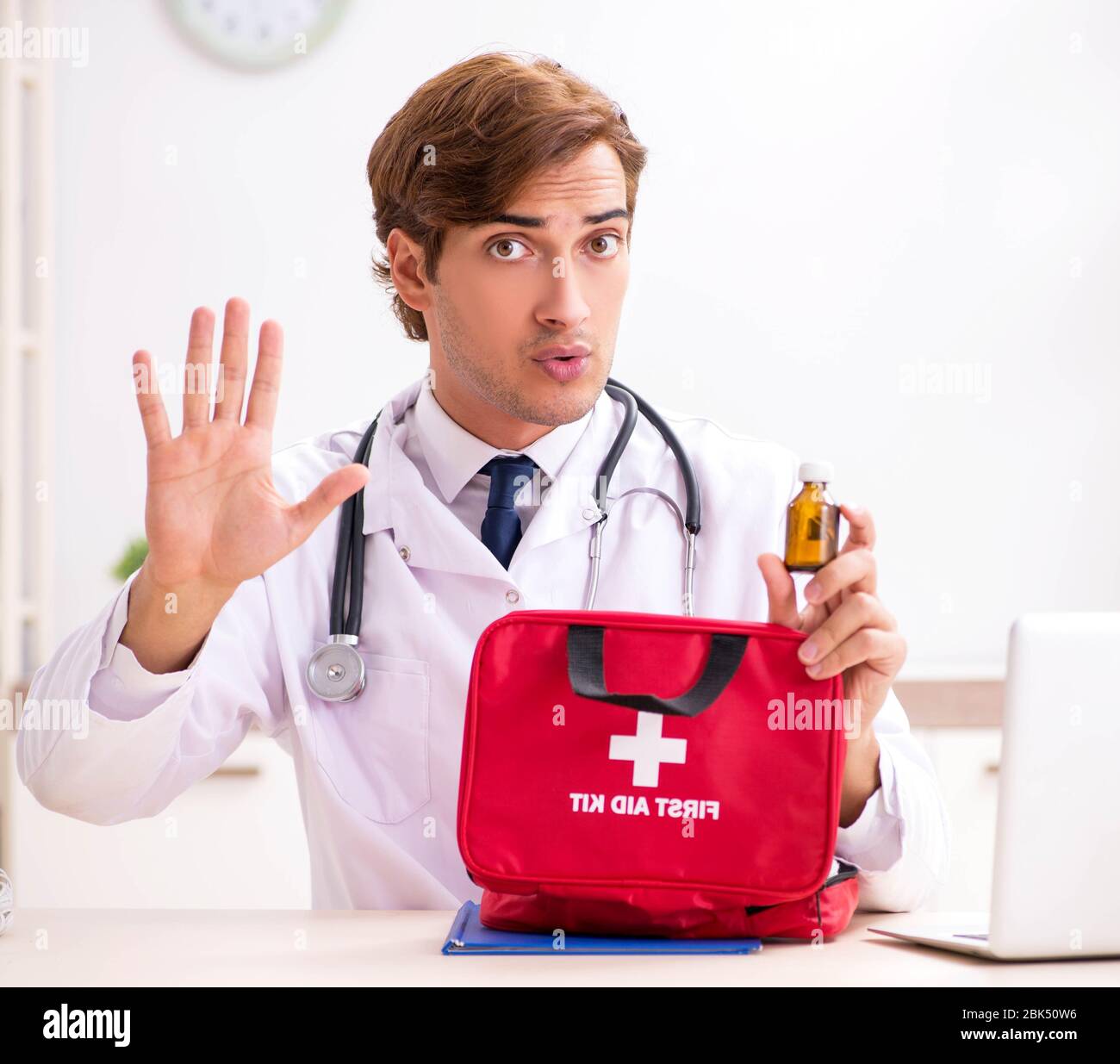 The young doctor with first aid kit in hospital Stock Photo - Alamy