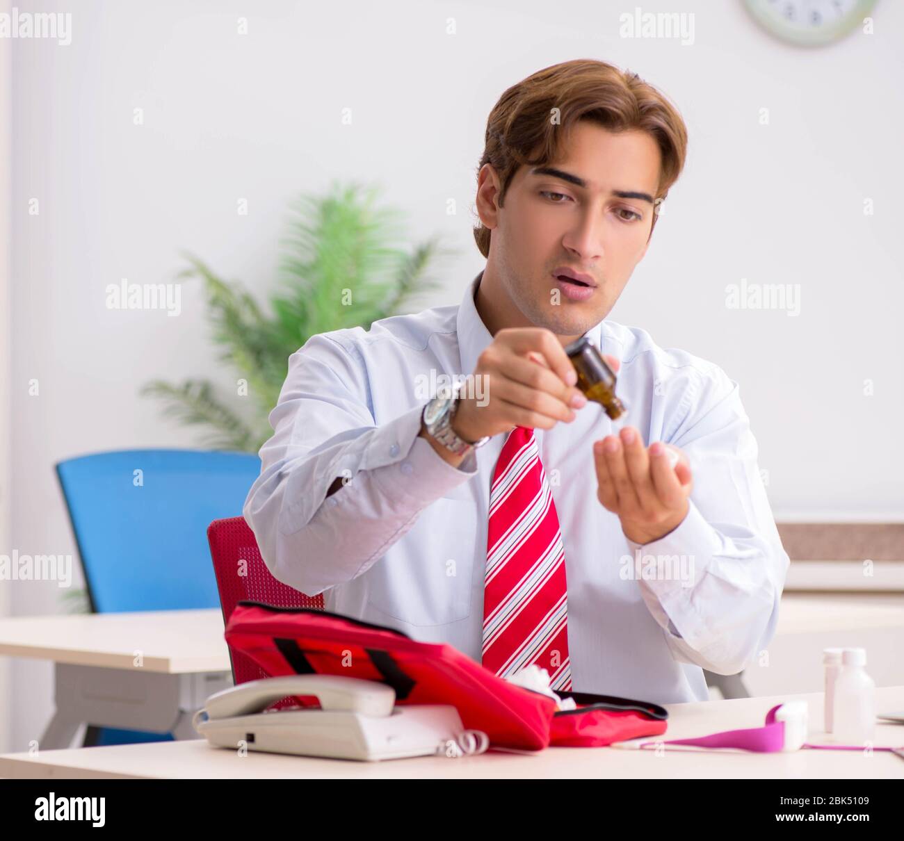 The man with first aid kit in the office Stock Photo - Alamy
