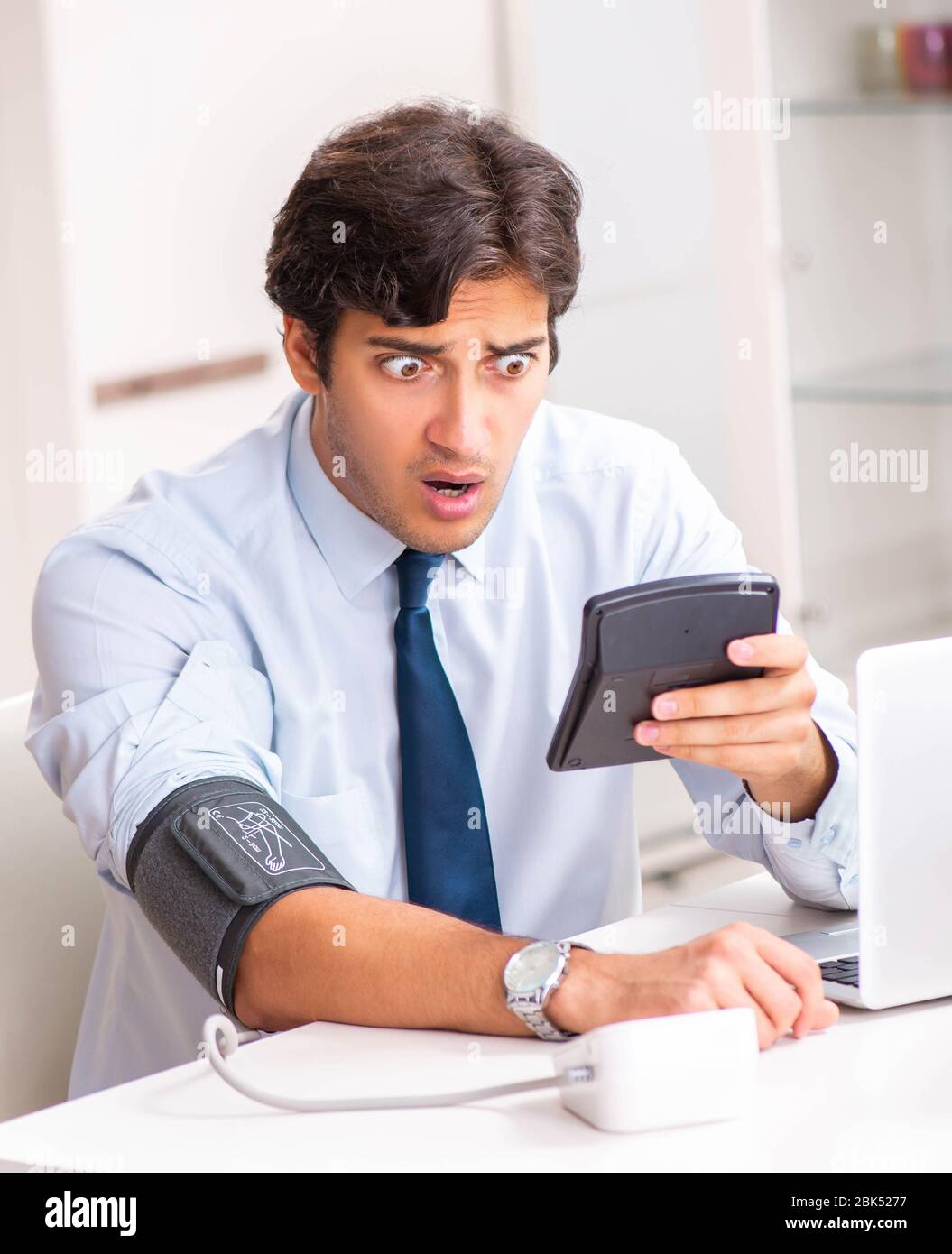 The man under stress measuring his blood pressure Stock Photo - Alamy