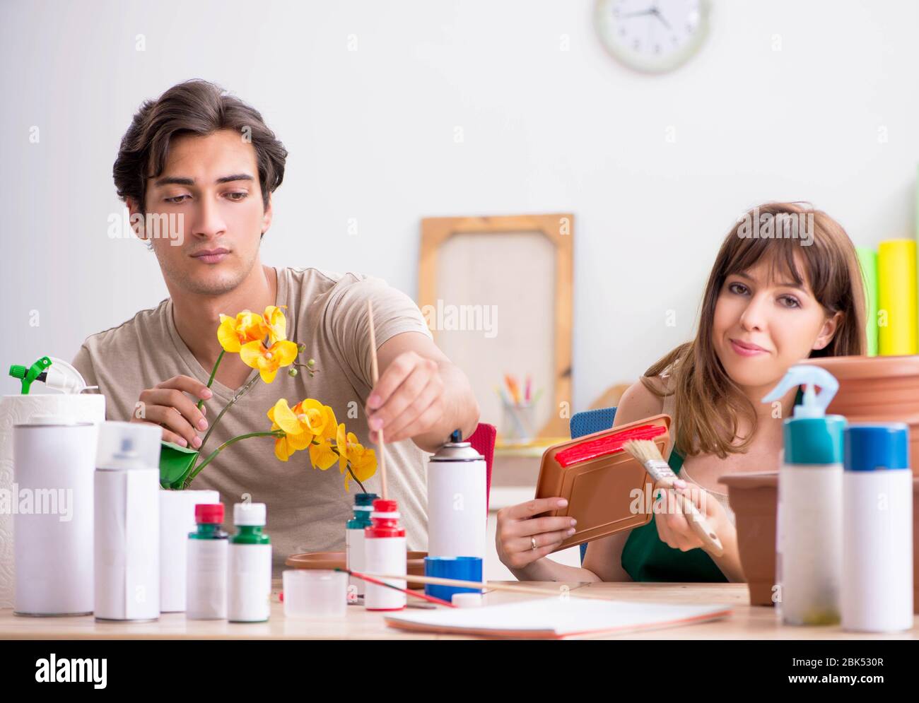 The couple decorating pots in workshop during class Stock Photo - Alamy