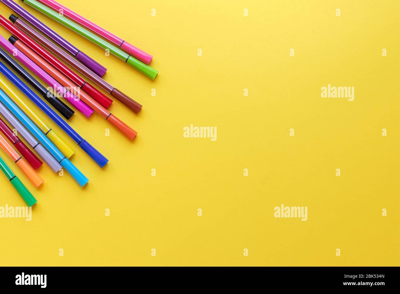 Many different highlighters, crayons and markers of various colours on ...