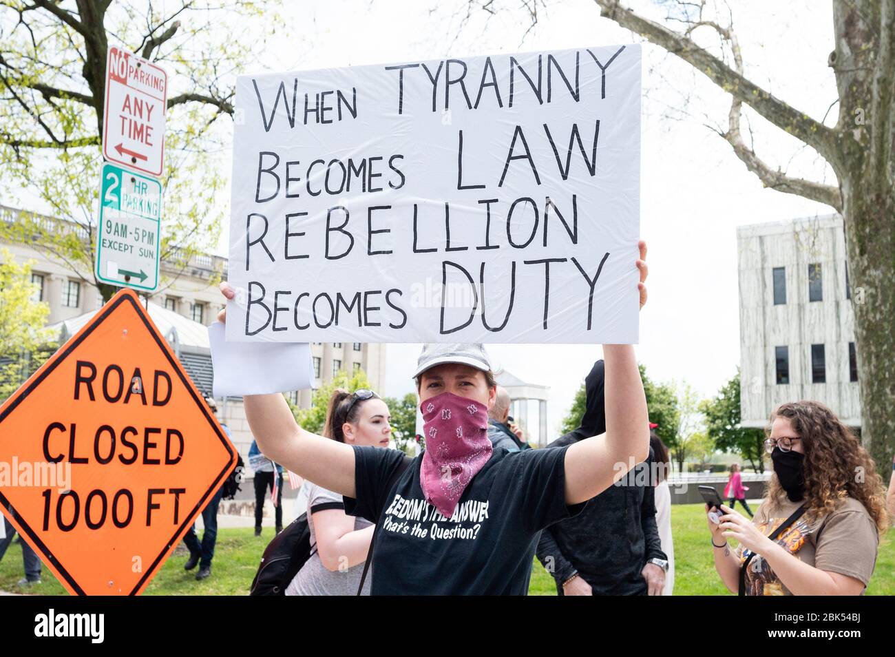 A protester holds a placard that says When Tyranny Becomes Law ...