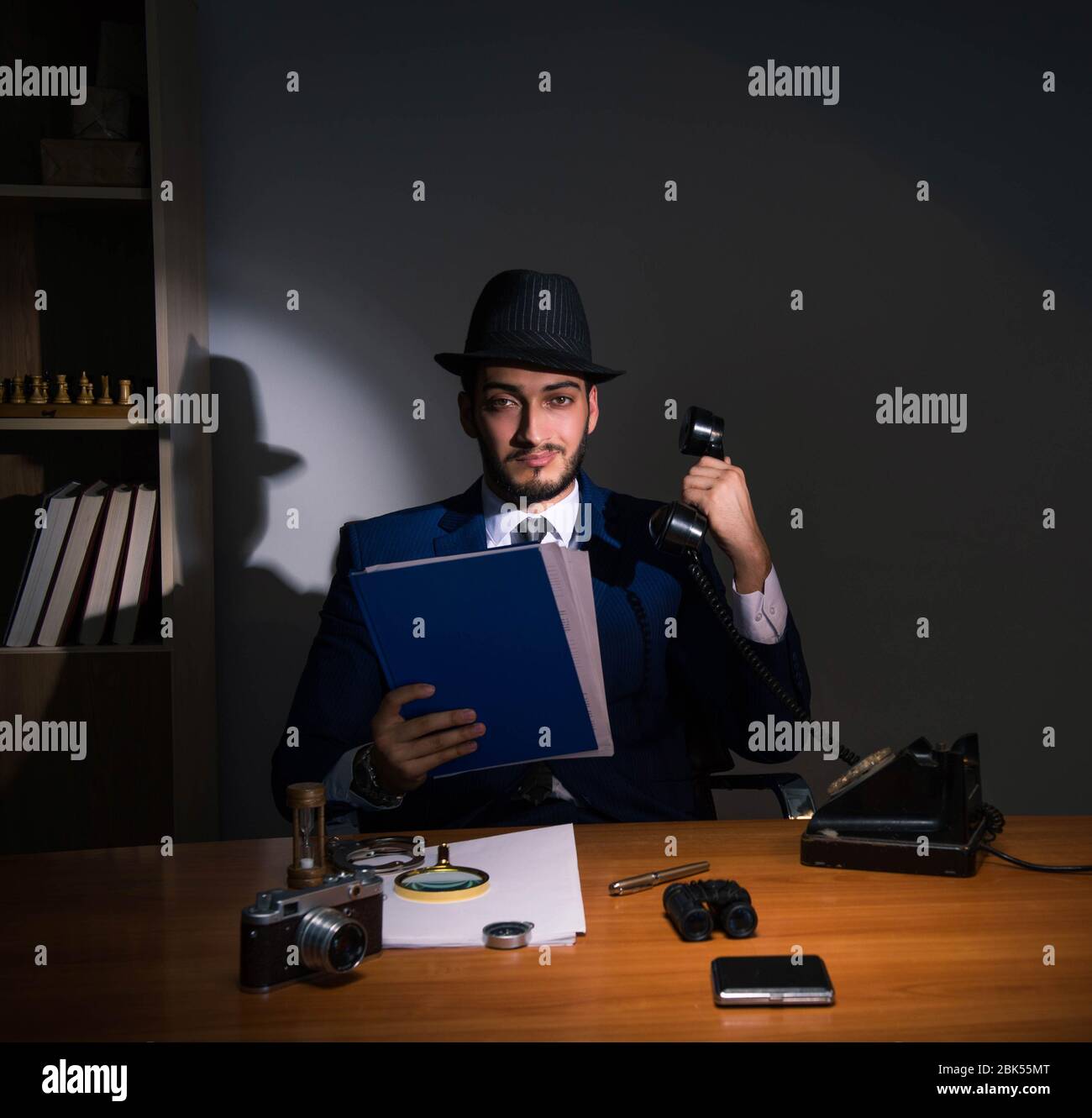 The detective sitting in dark room in vintage concept Stock Photo - Alamy